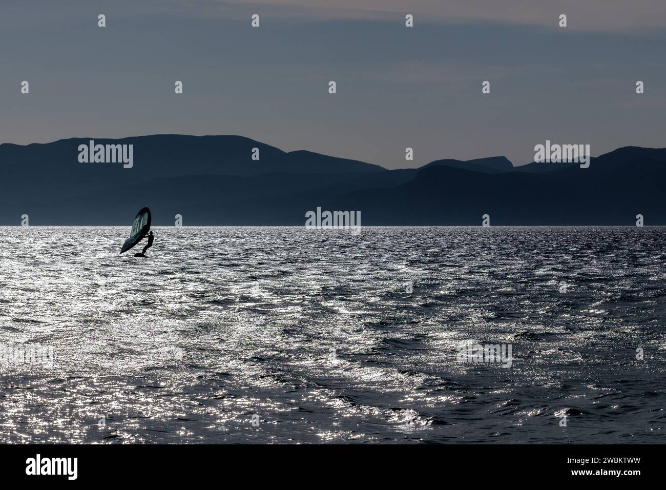 View of a tourist enjoying wing foil surfing at the Mylopotas beach in ...