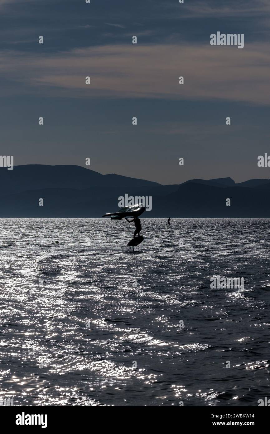 View of a tourist enjoying wing foil surfing at the Mylopotas beach in ...