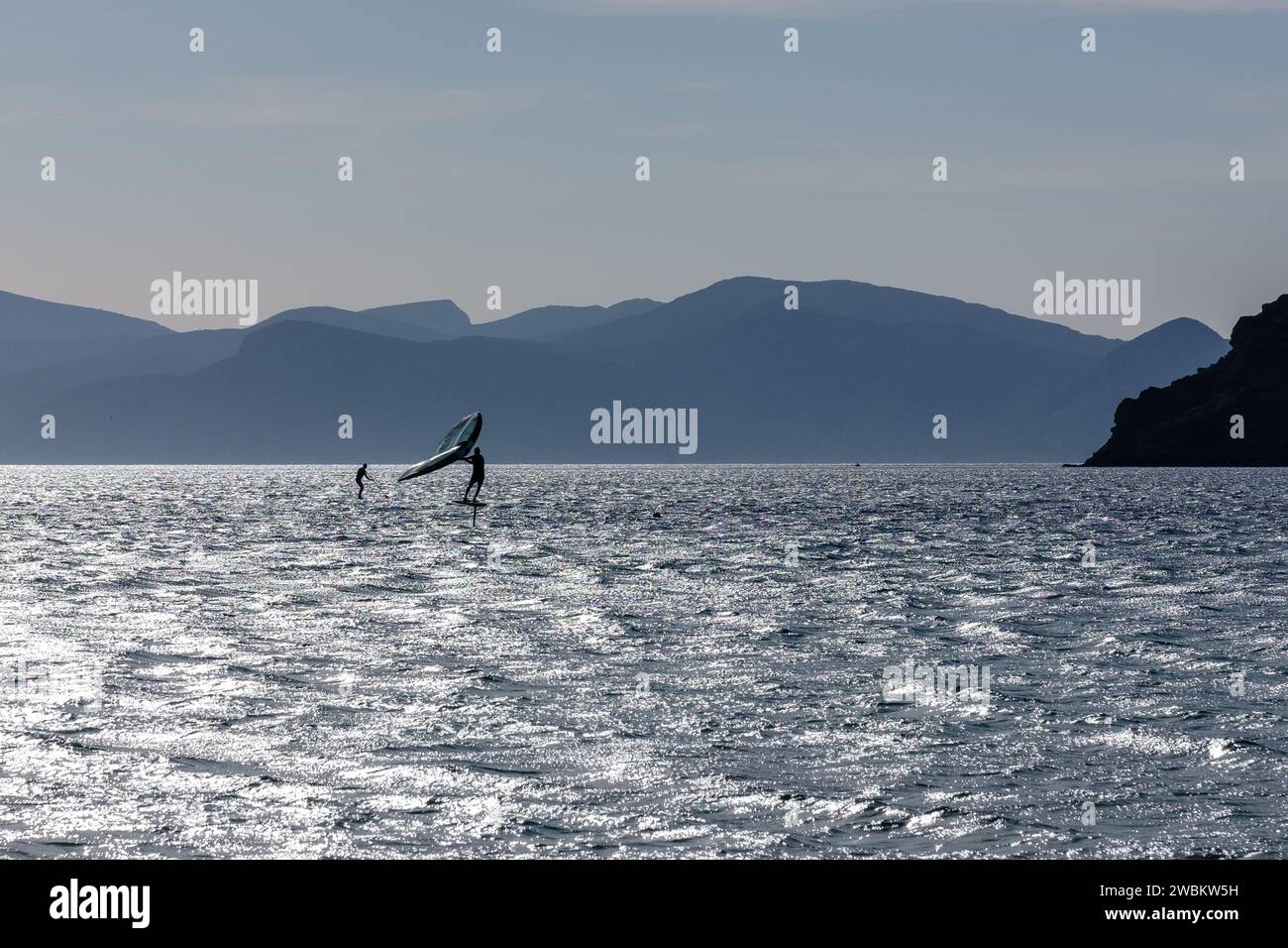 View of a tourist enjoying wing foil surfing at the Mylopotas beach in ...