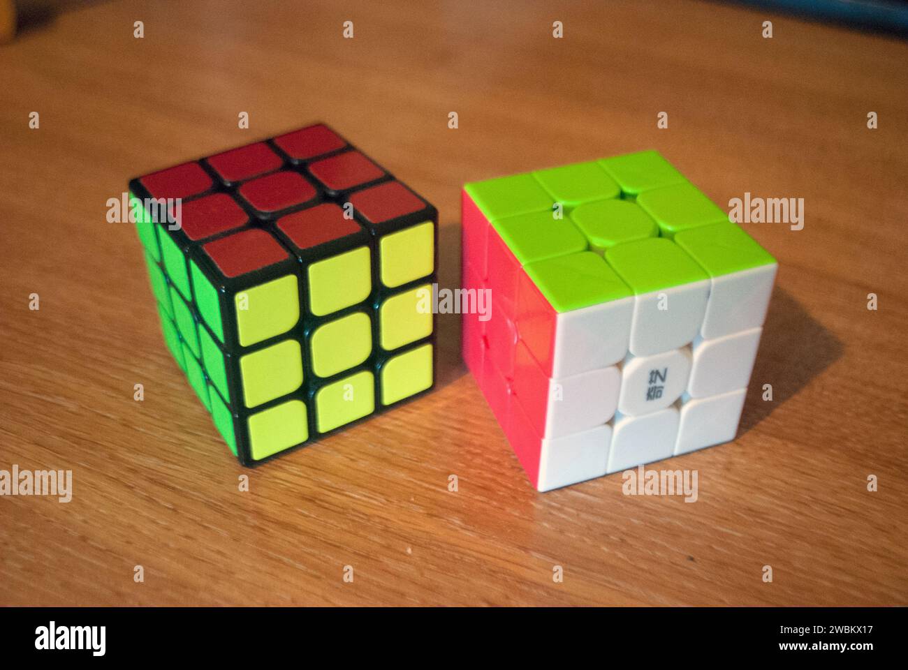 Two rubik's cubes on a desk Stock Photo - Alamy