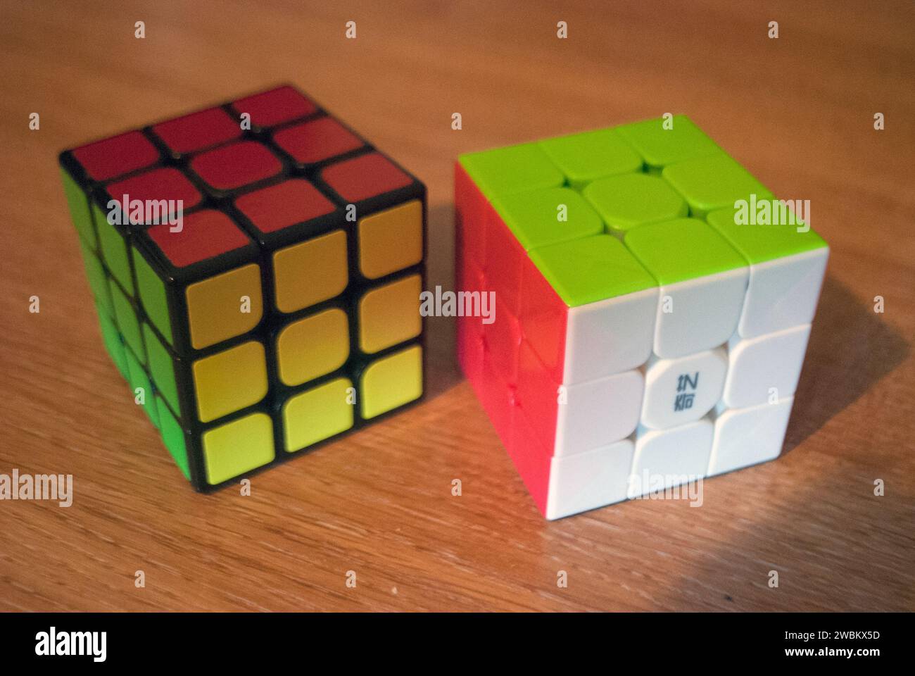 Two rubik's cubes on a desk Stock Photo - Alamy