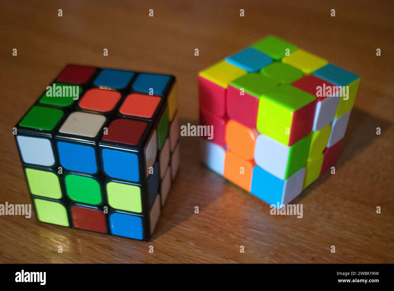 Two scrambled rubik's cubes on a desk Stock Photo - Alamy