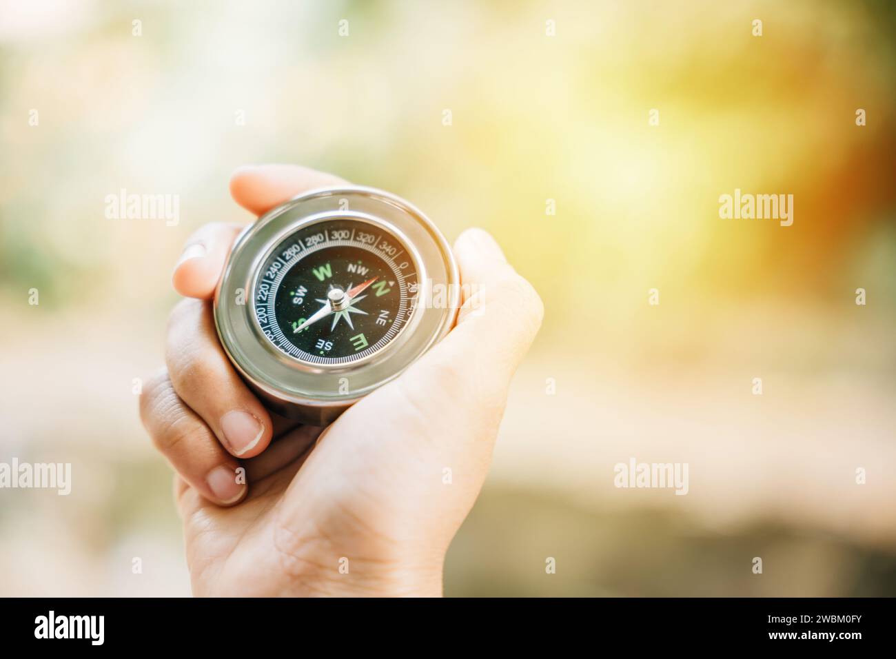 Traveler holds a compass in a park finding her way through the ...