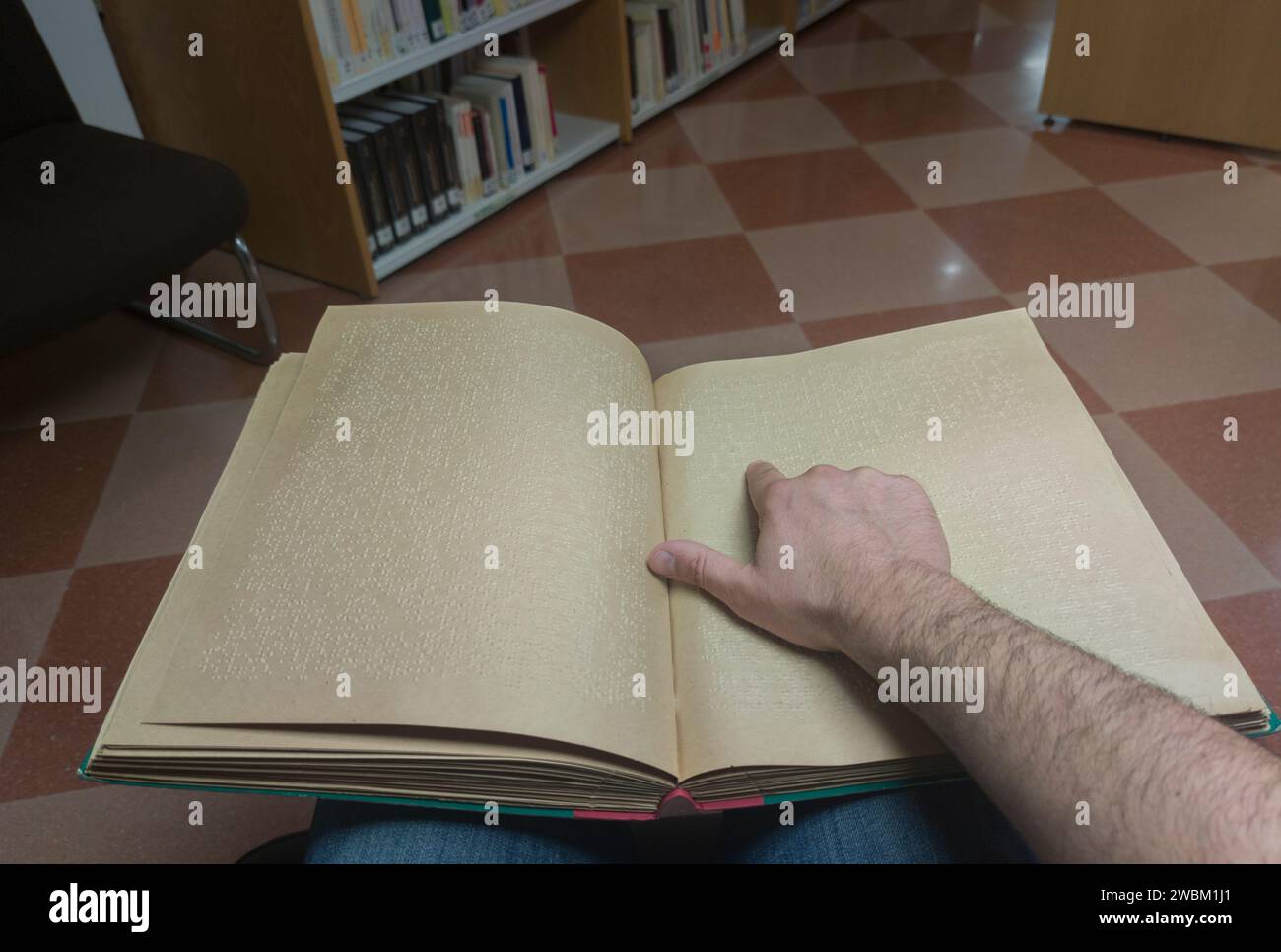 Blind male reading braille language book at library. Point of view shot ...