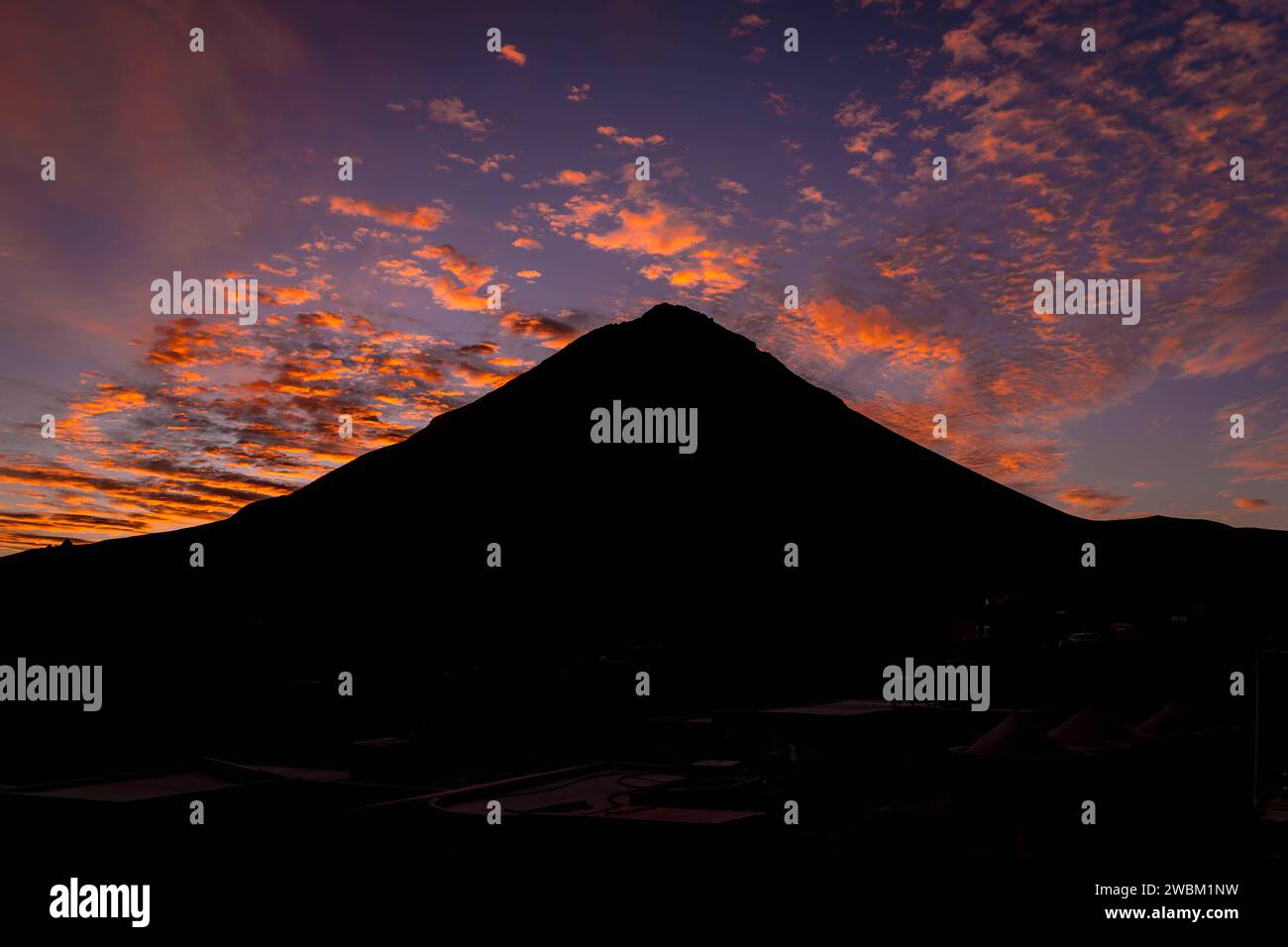 The silhouette of Pico do Fogo volcano and colorful clouds during the ...