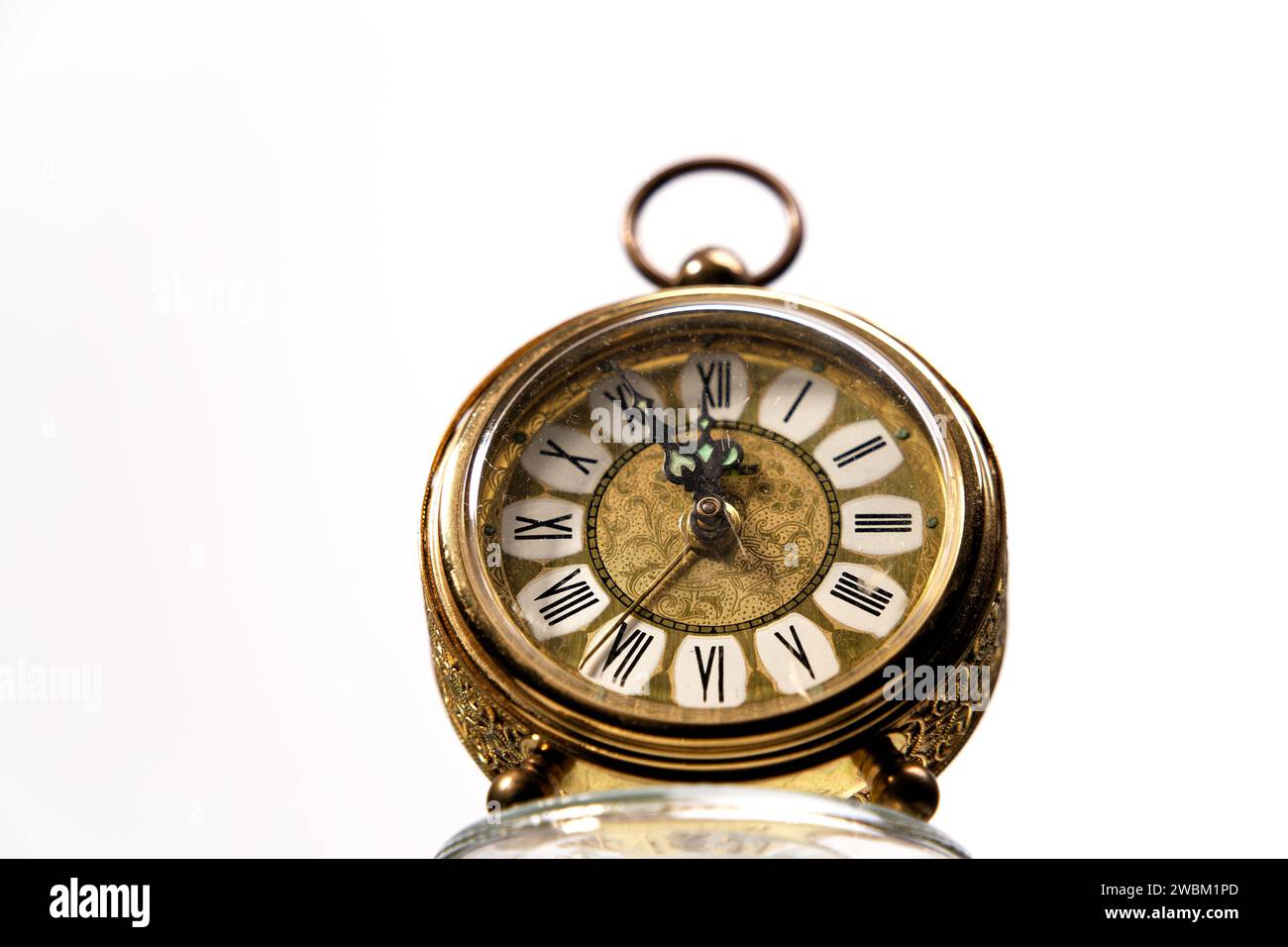 an old golden analog alarm clock with mechanical movement isolated on a ...