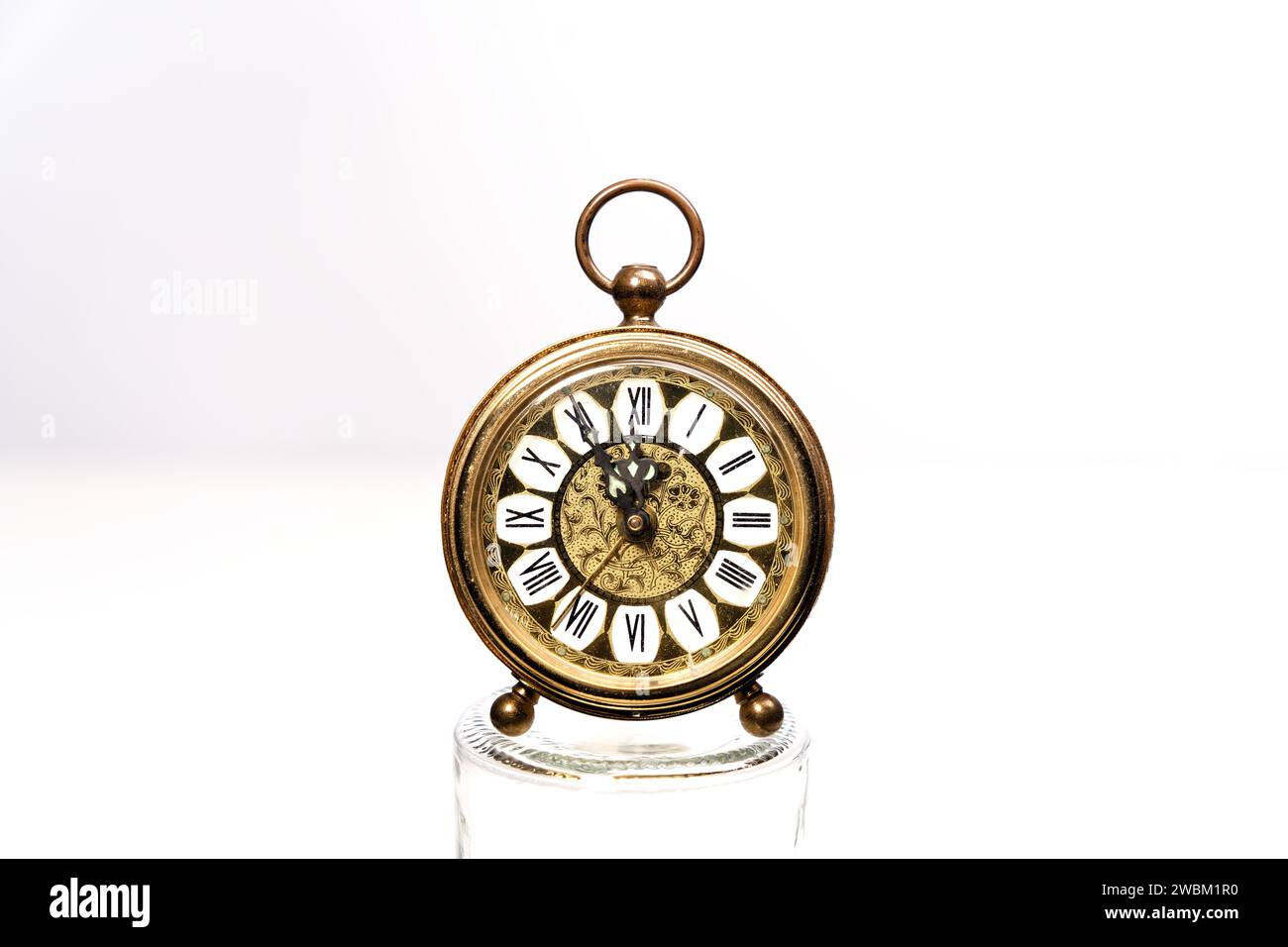 an old golden analog alarm clock with mechanical movement isolated on a ...