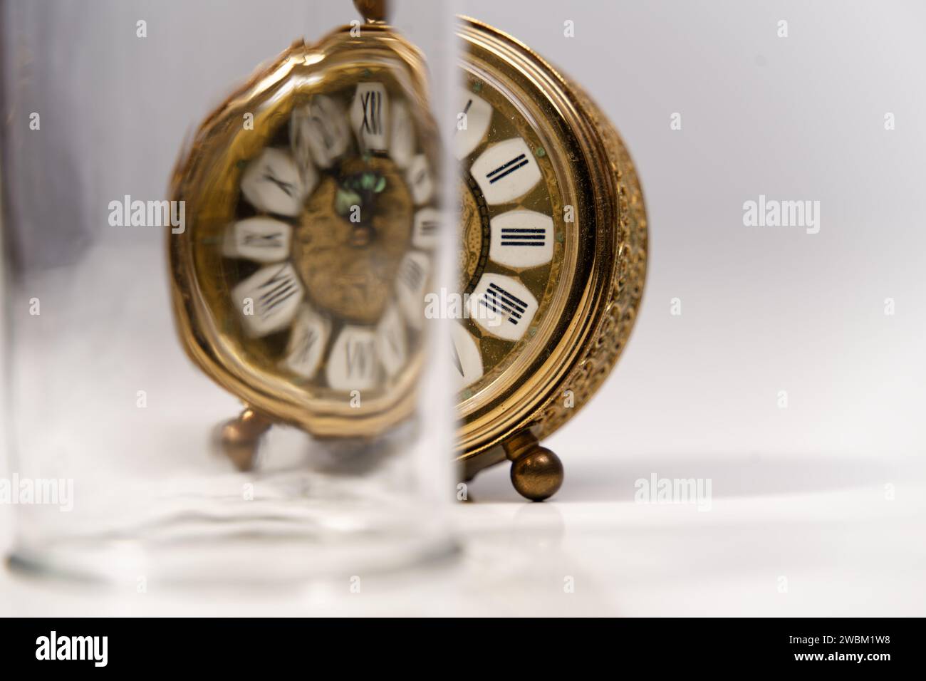 an old golden analog alarm clock with mechanical movement isolated on a ...