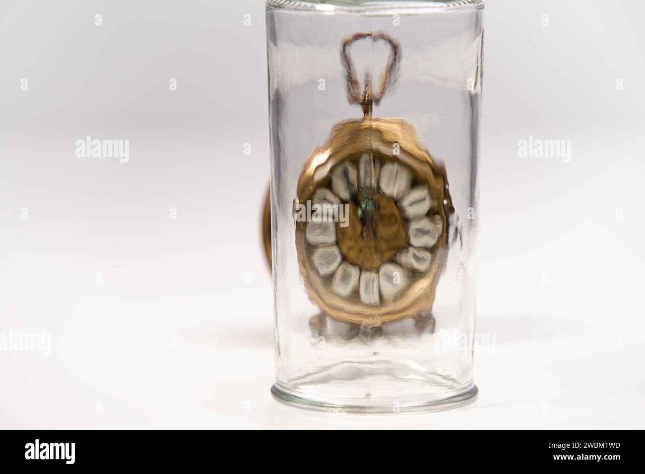 an old golden analog alarm clock with mechanical movement isolated on a ...