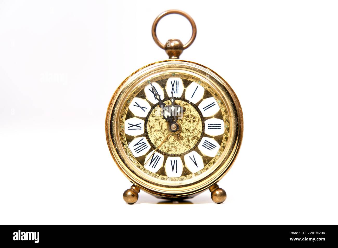 an old golden analog alarm clock with mechanical movement isolated on a ...