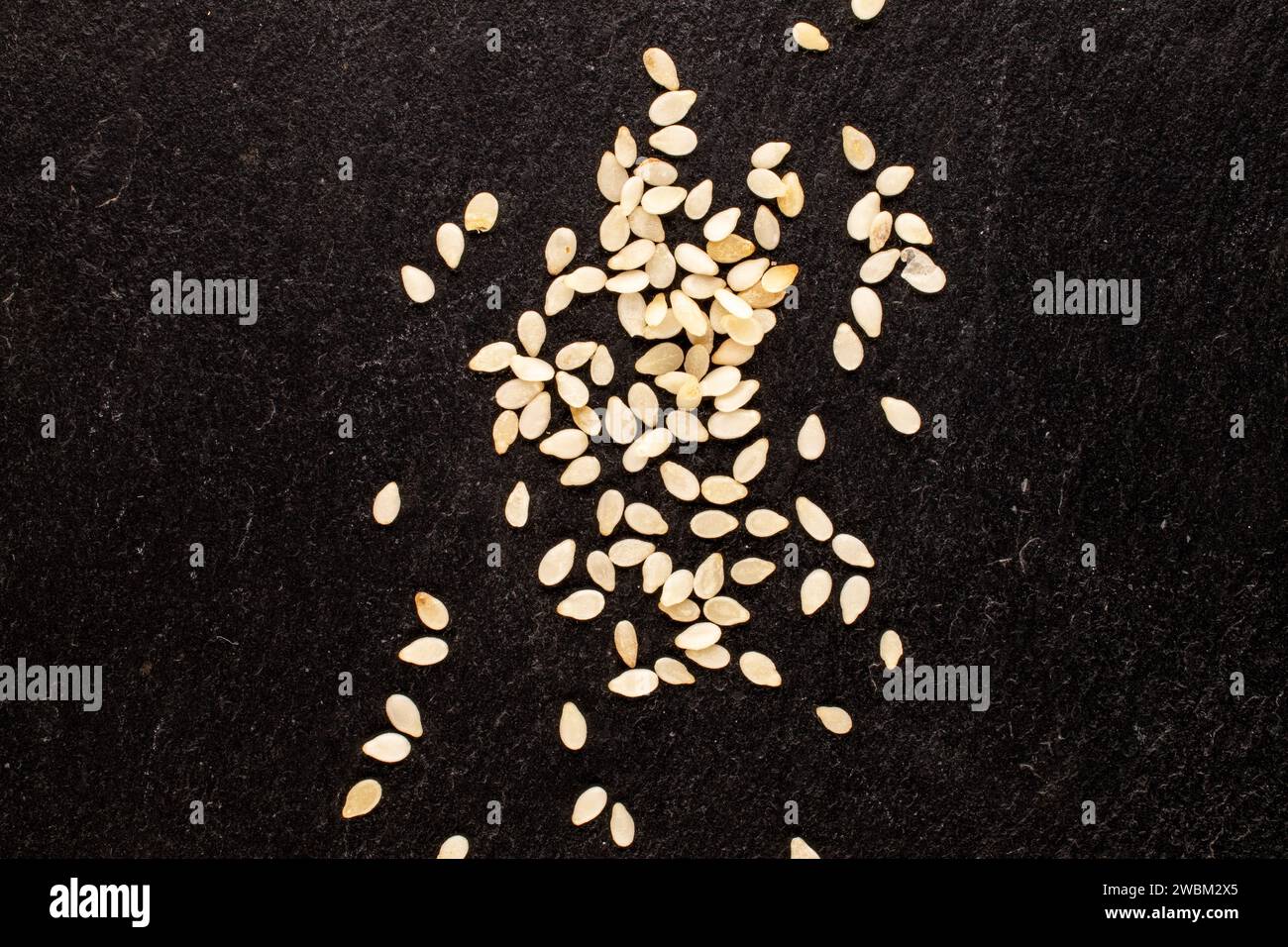 White sesame on slate stone, macro, top view Stock Photo - Alamy