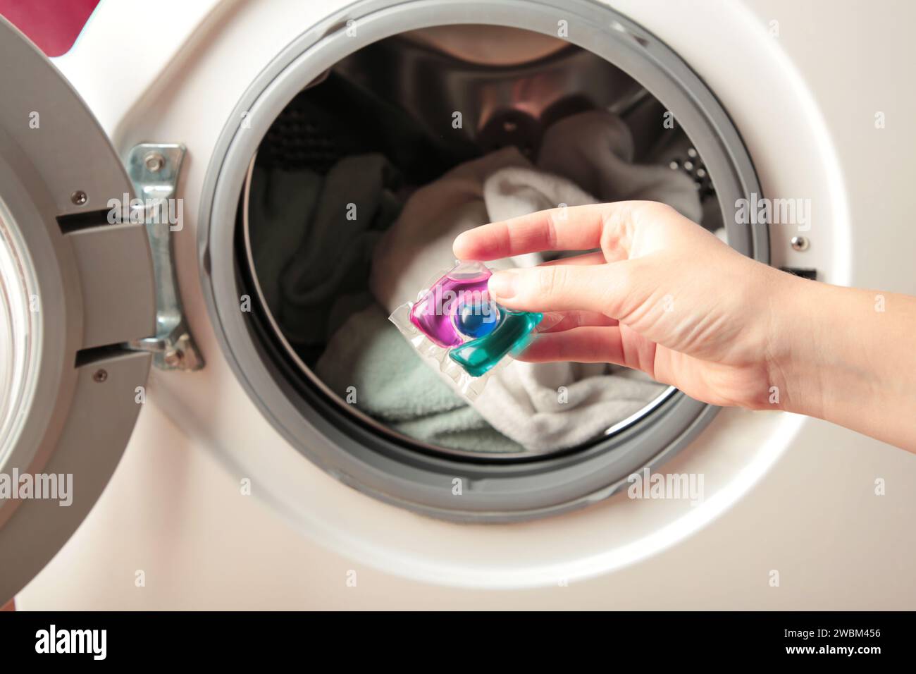 Hand holding gel caps for washing machine. Household laundry equipment ...