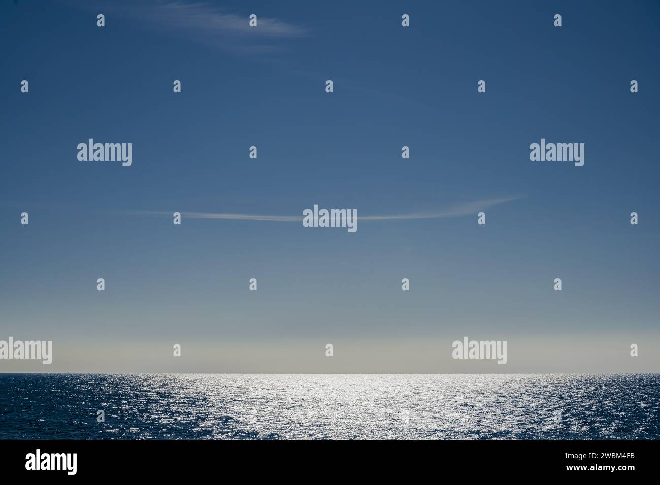 Very thin cloud floats on the sea horizon in a beautiful blue sky Stock ...