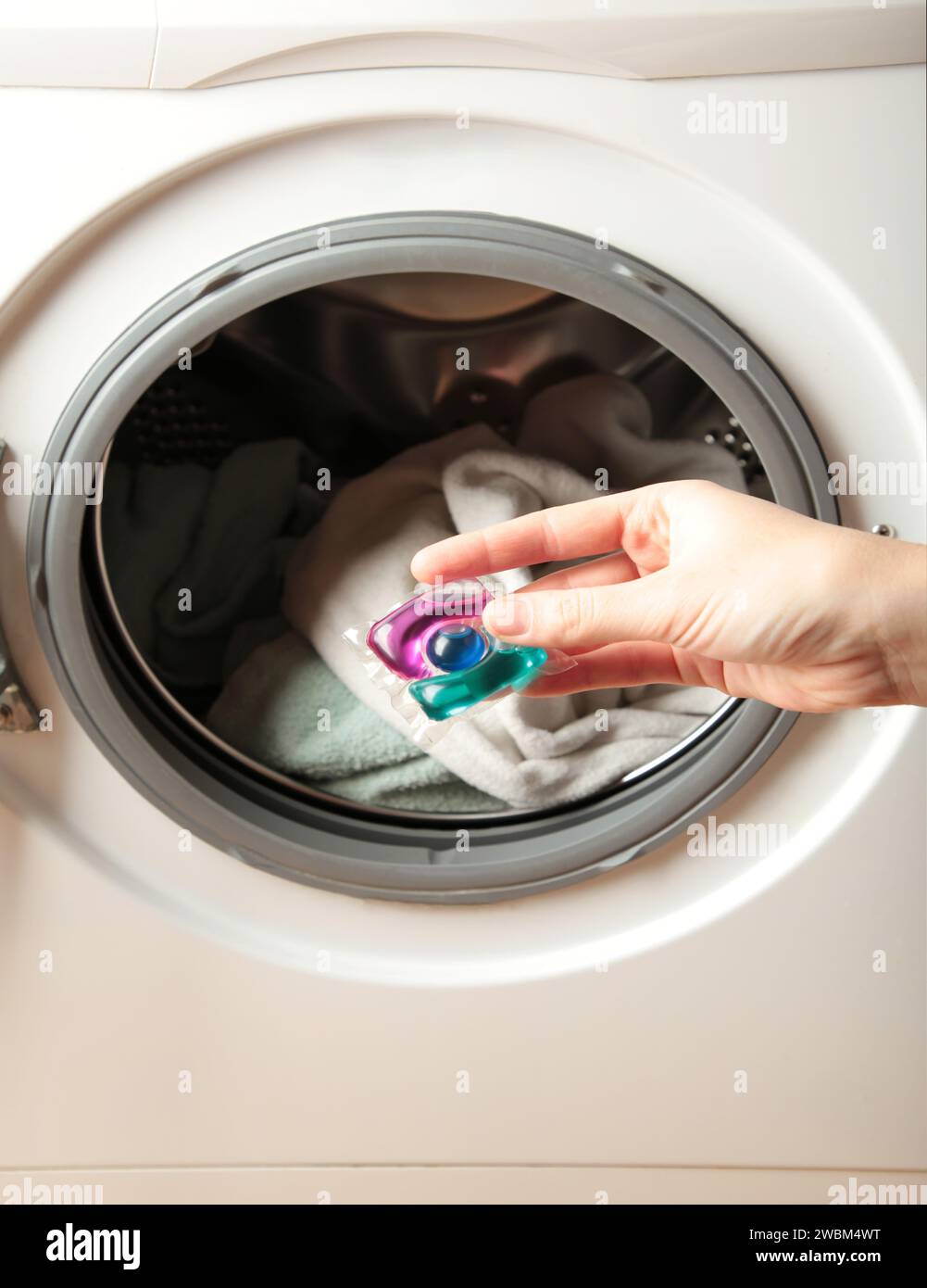 Hand holding gel caps for washing machine. Household laundry equipment ...