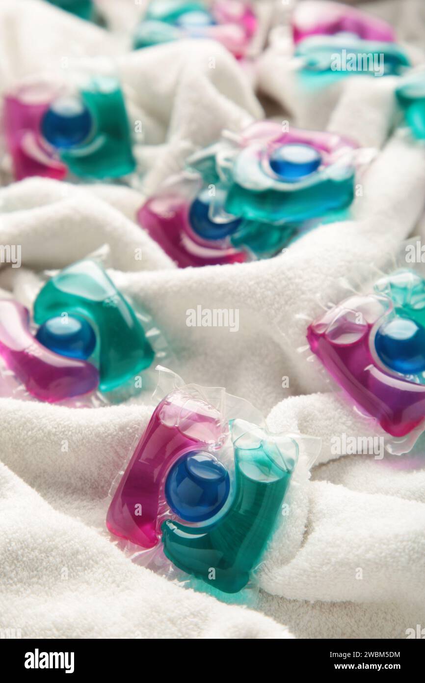 Washing gel capsule pods with laundry detergent on a pile of white ...