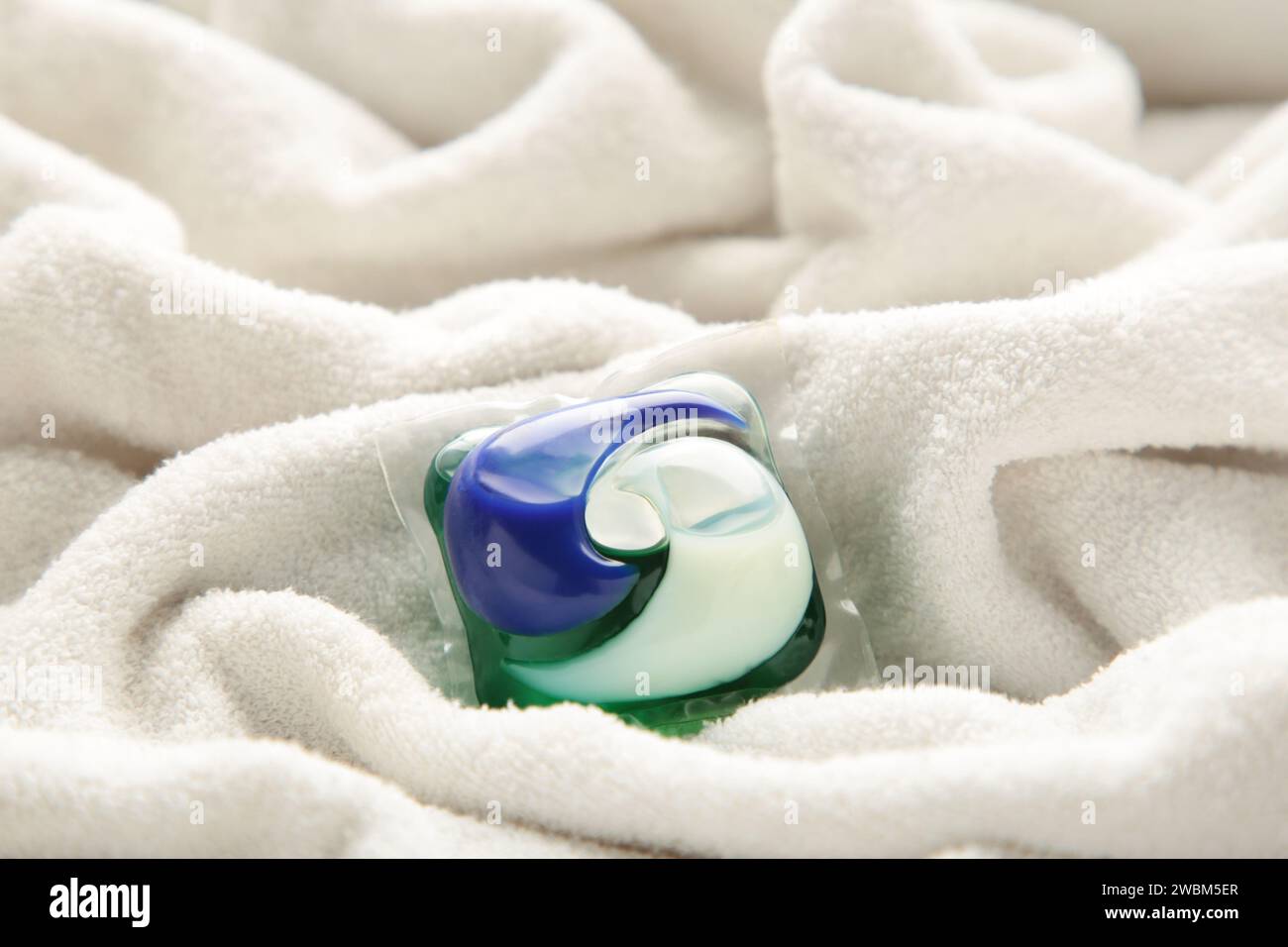 Washing gel capsule pods with laundry detergent on a pile of white ...