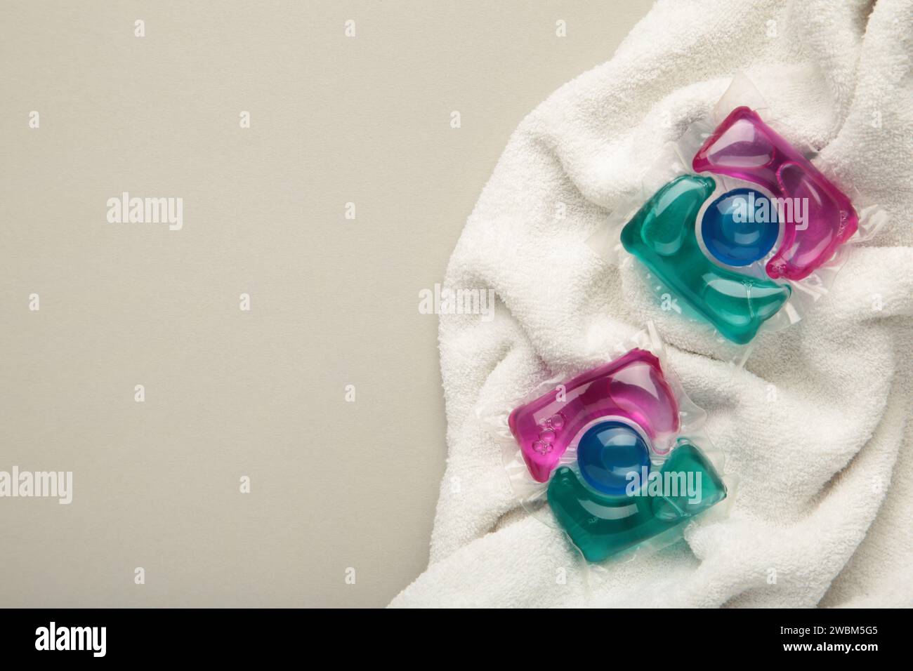 Washing gel capsule pods with laundry detergent on a pile of white ...