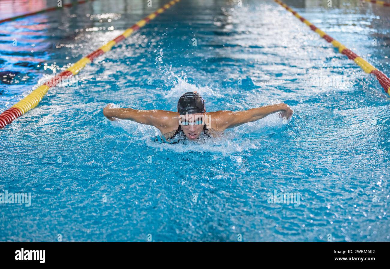 Front view of a female swimmer swimming butterfly style, a stroke ...