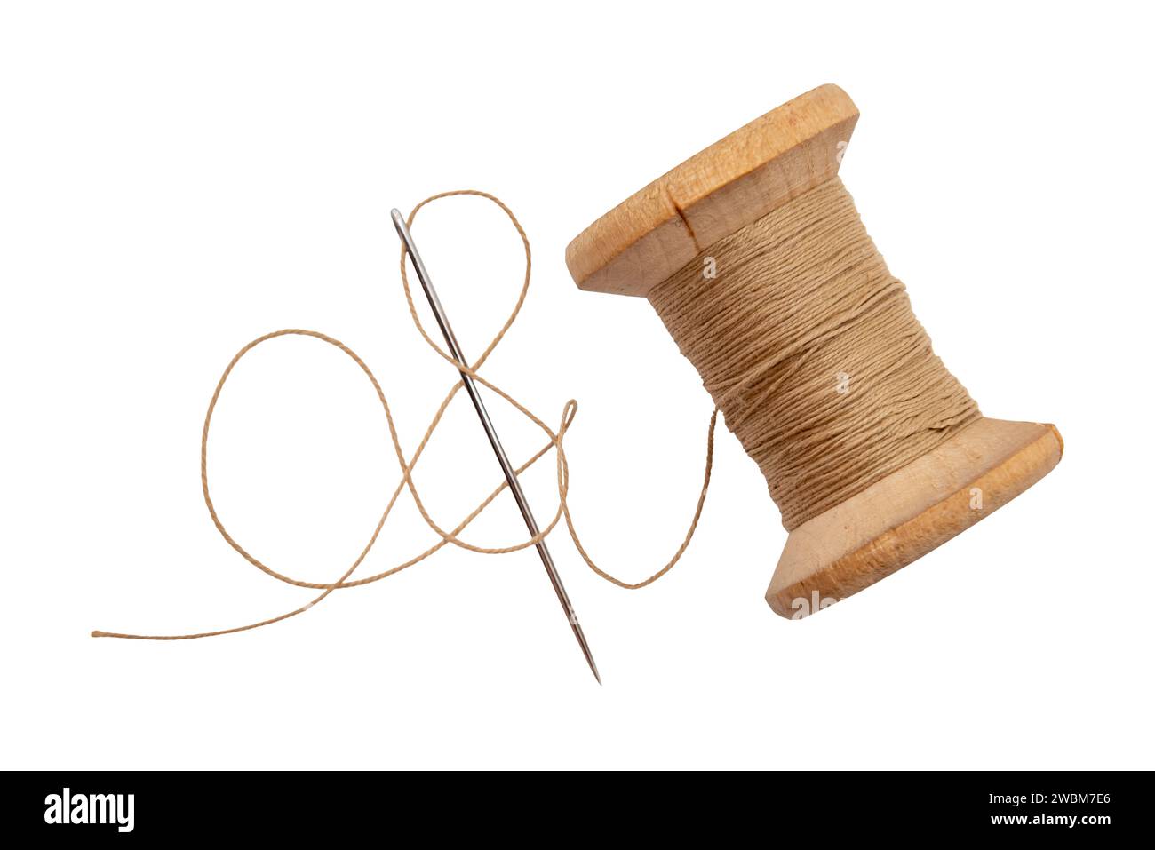 Old wood spool of thread and needle on a white background. Sewing ...