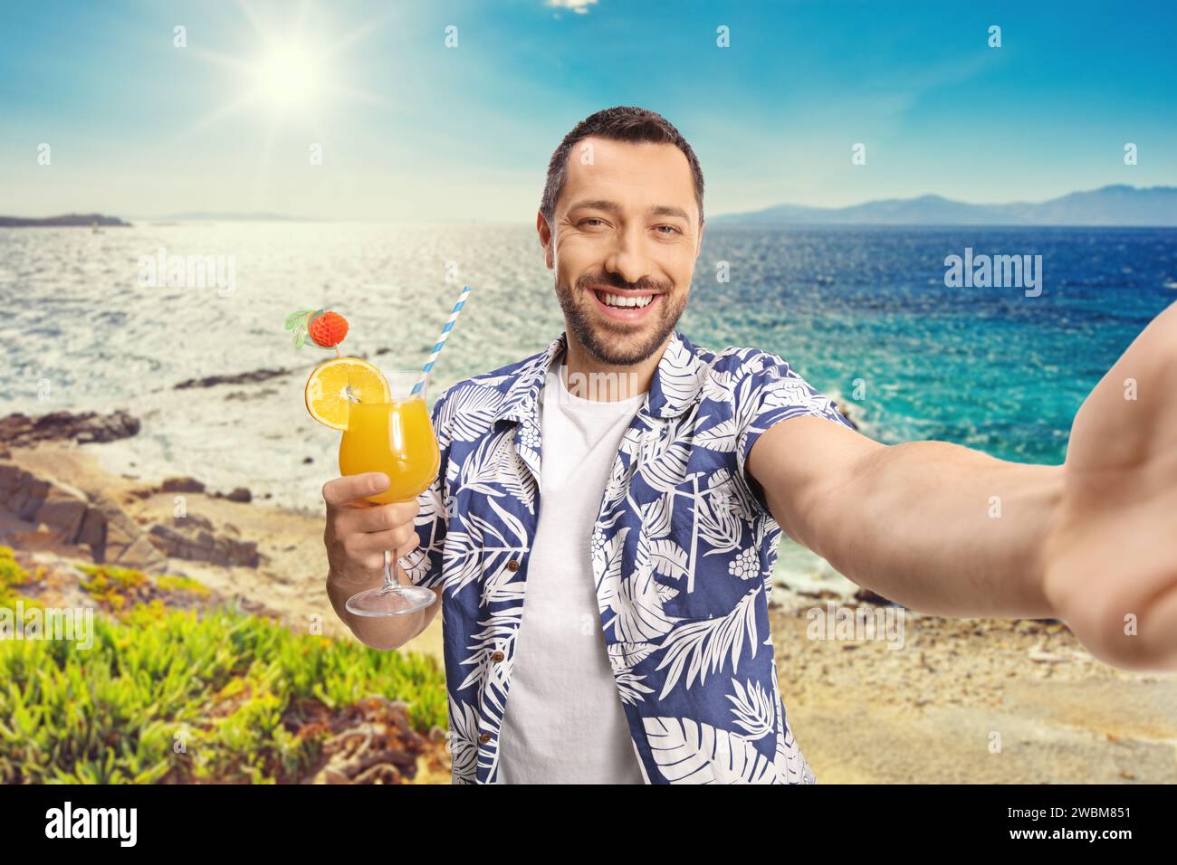 Guy holding a cocktail and taking a selfie at a beach in Greece Stock ...