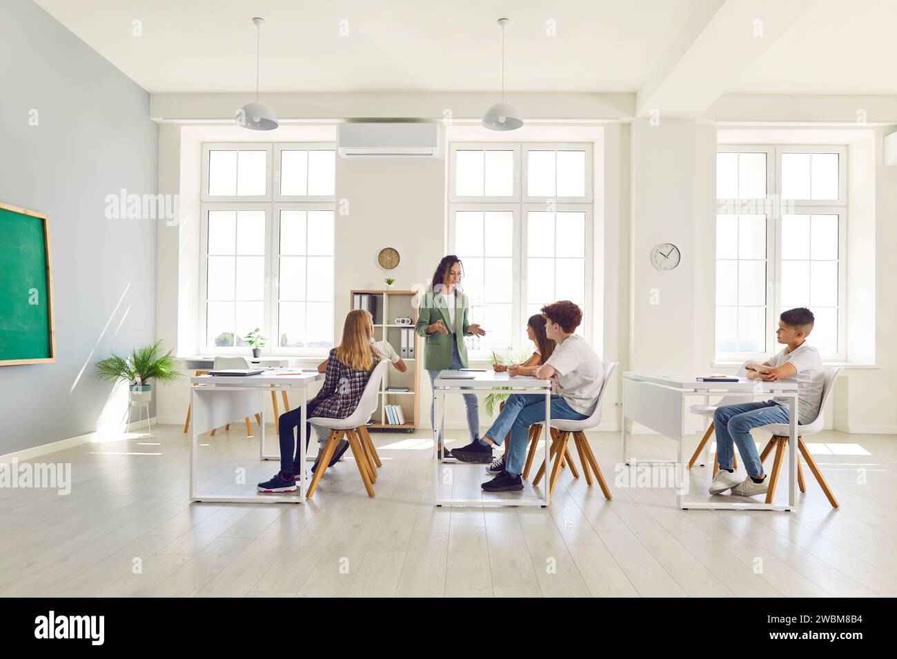Female friendly teacher at the lesson in junior high school ...