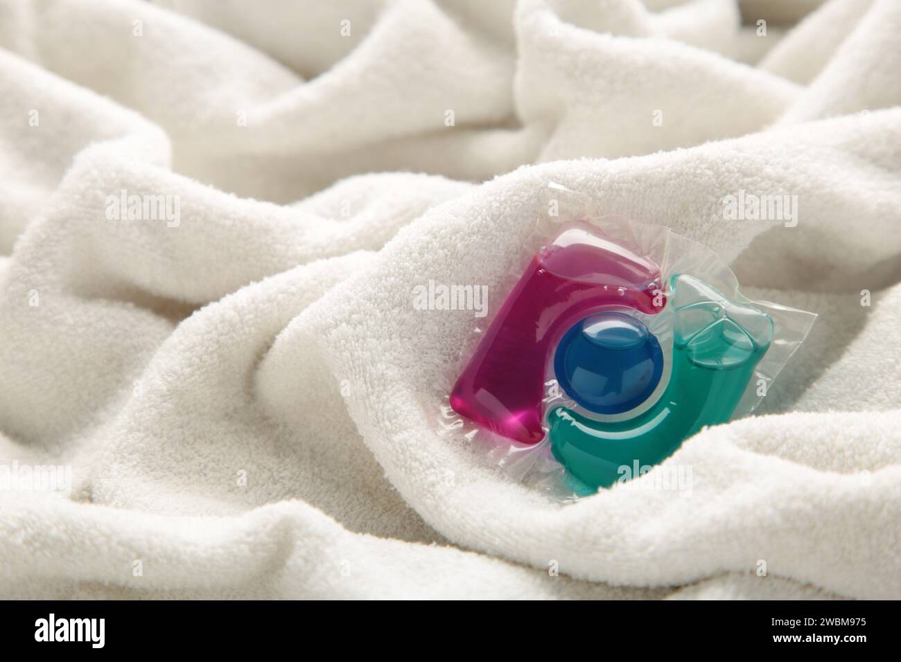 Washing gel capsule pods with laundry detergent on a pile of white ...