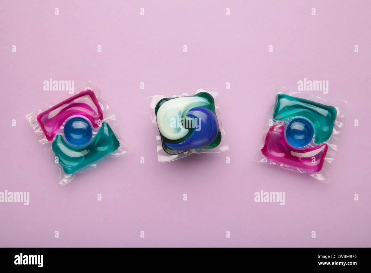 Laundry capsule detergent pods for washing clothes on purple background ...