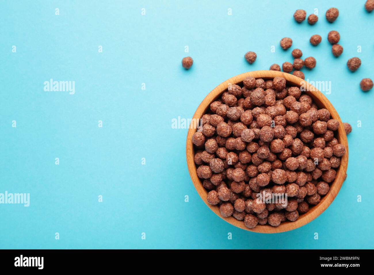 Chocolate corn balls in wooden bowl on blue background. Top view Stock ...