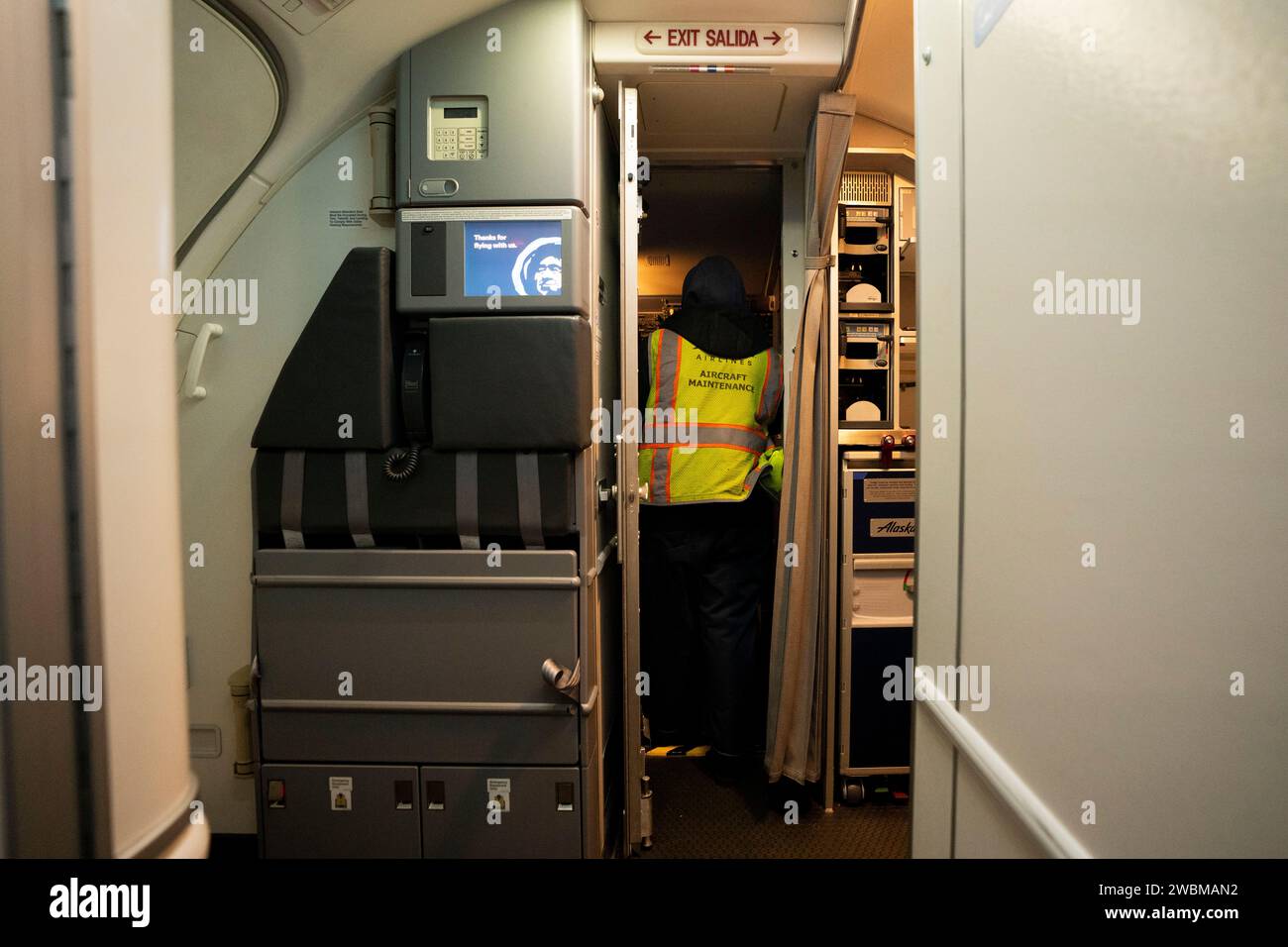 A maintenance worker stands in the cockpit of an Alaska Airlines Boeing ...