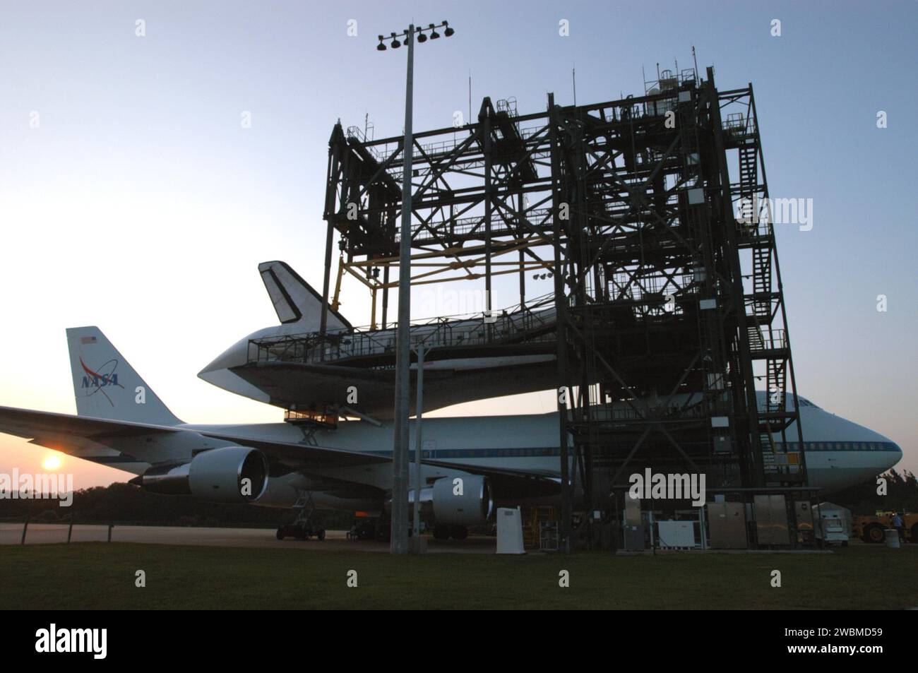 KENNEDY SPACE CENTER, FLA. - The sun is setting behind the tail of the ...