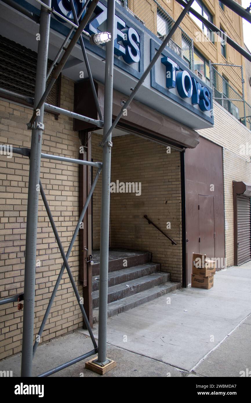 A bright, yellow street sign outside of an apartment building with the ...