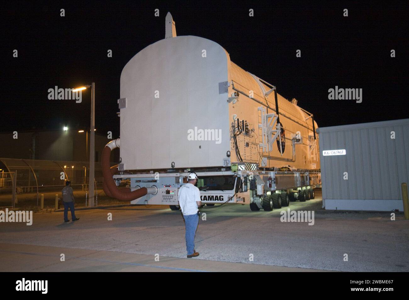 United Space Alliance workers assisted with handling a payload canister ...