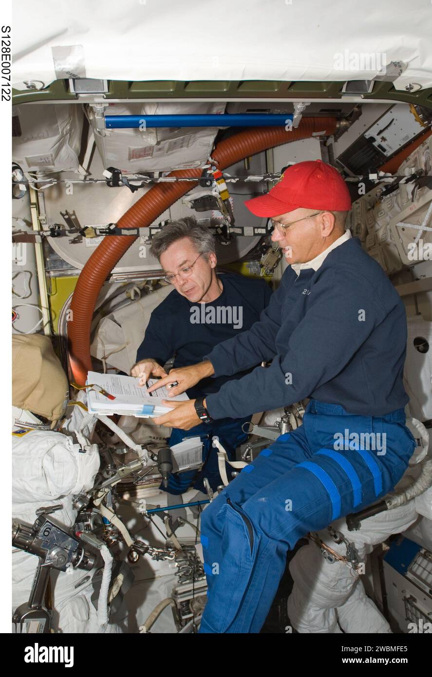 Astronauts Rick Sturckow and Robert Thirsk review a checklist in the ...