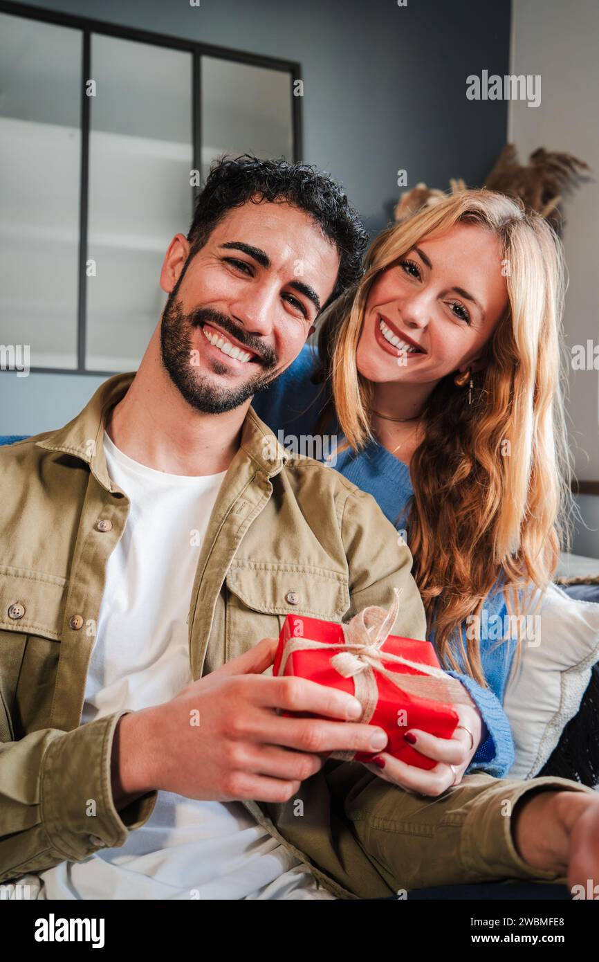 Vertical. Real young couple smiling looking at camera showing a ...