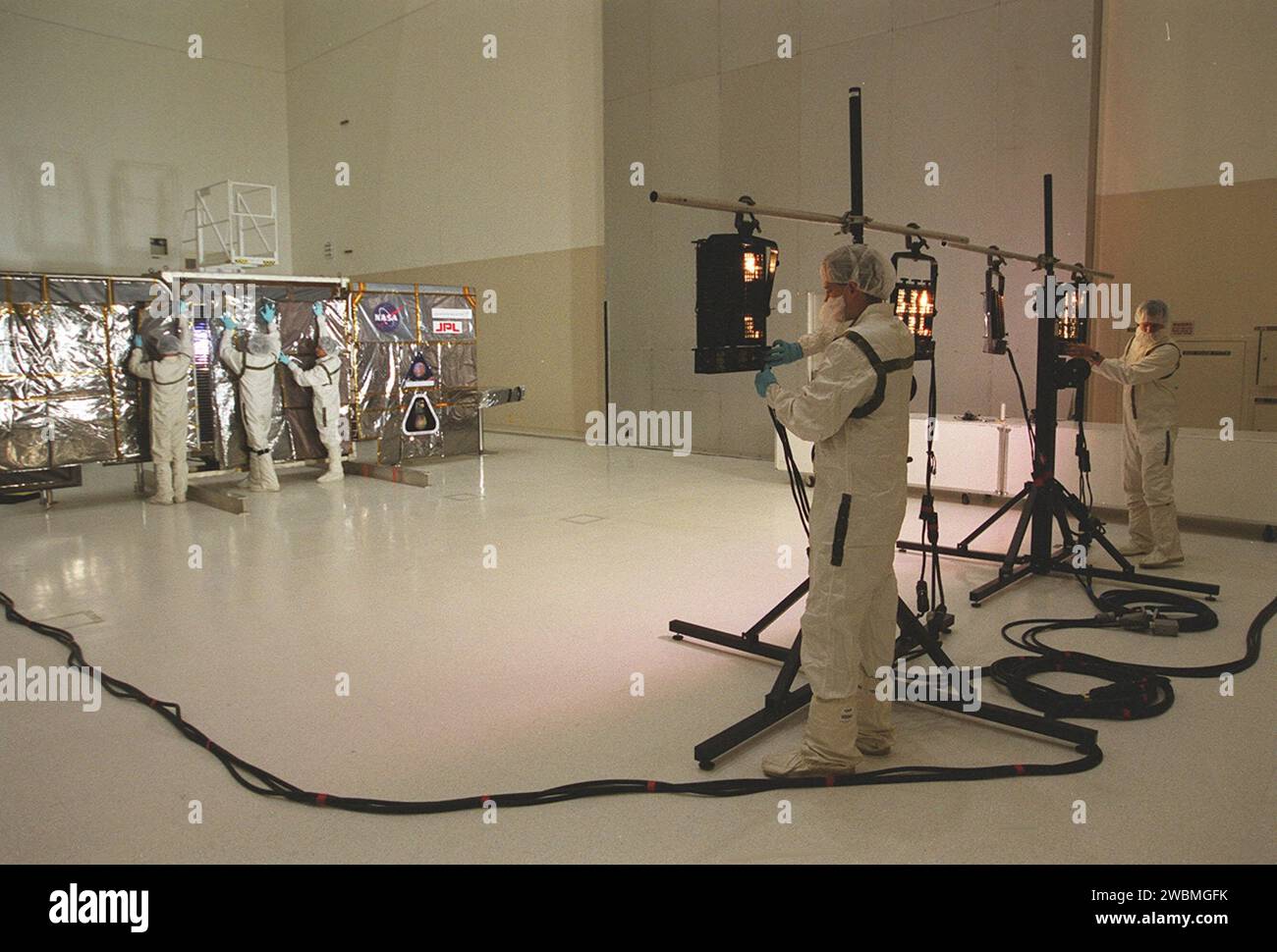 Workers set up illumination testing for the Mars Odyssey solar panels ...