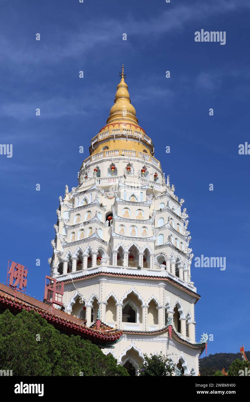 An impressive white and gold-colored temple structure stands tall ...