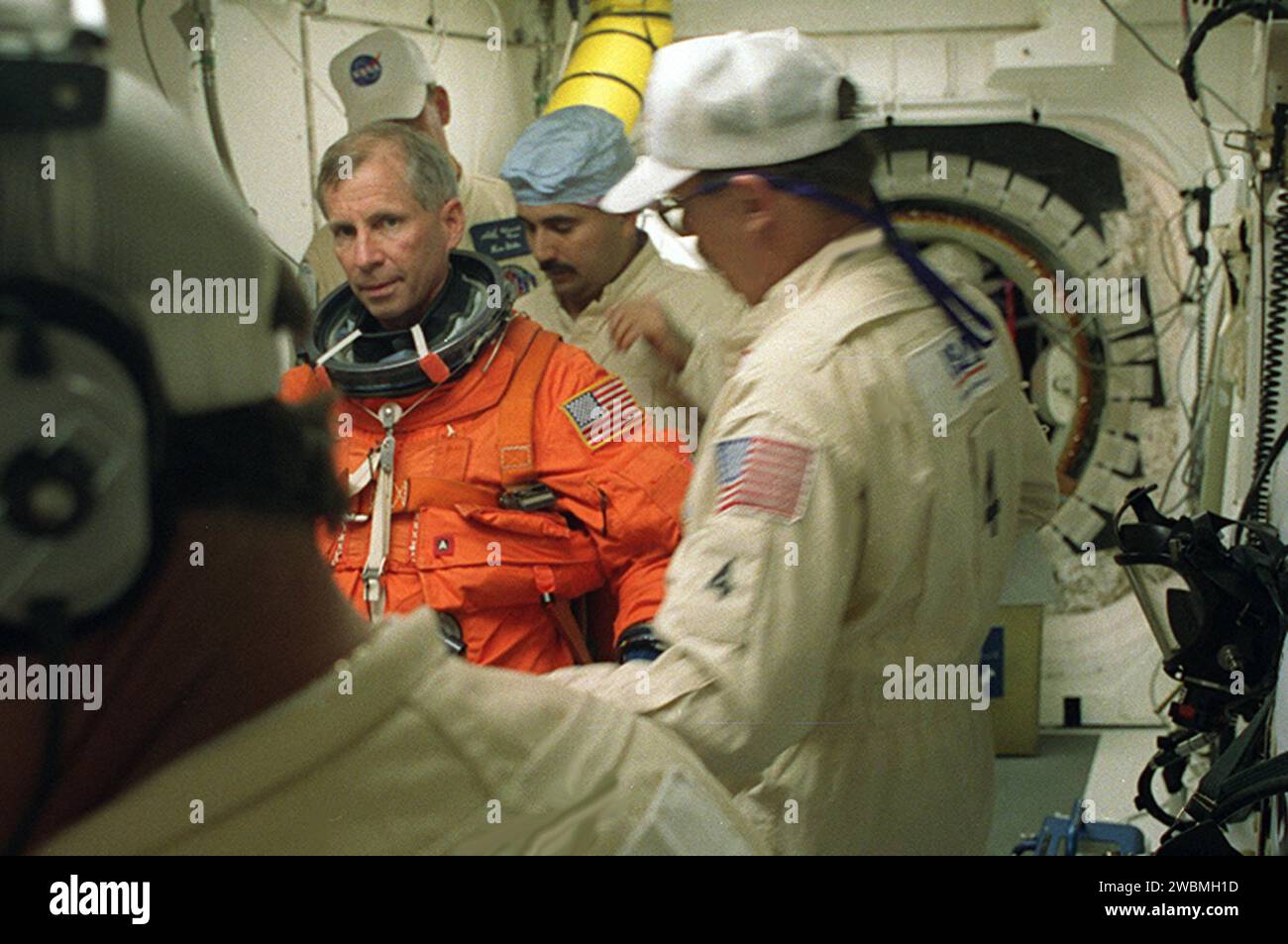 The closeout crew in the White Room help STS-98 Commander Ken Cockrell with final suitup before ...