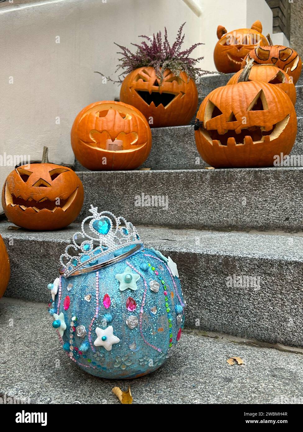 A collection of festive Halloween pumpkins sitting on the steps of a ...