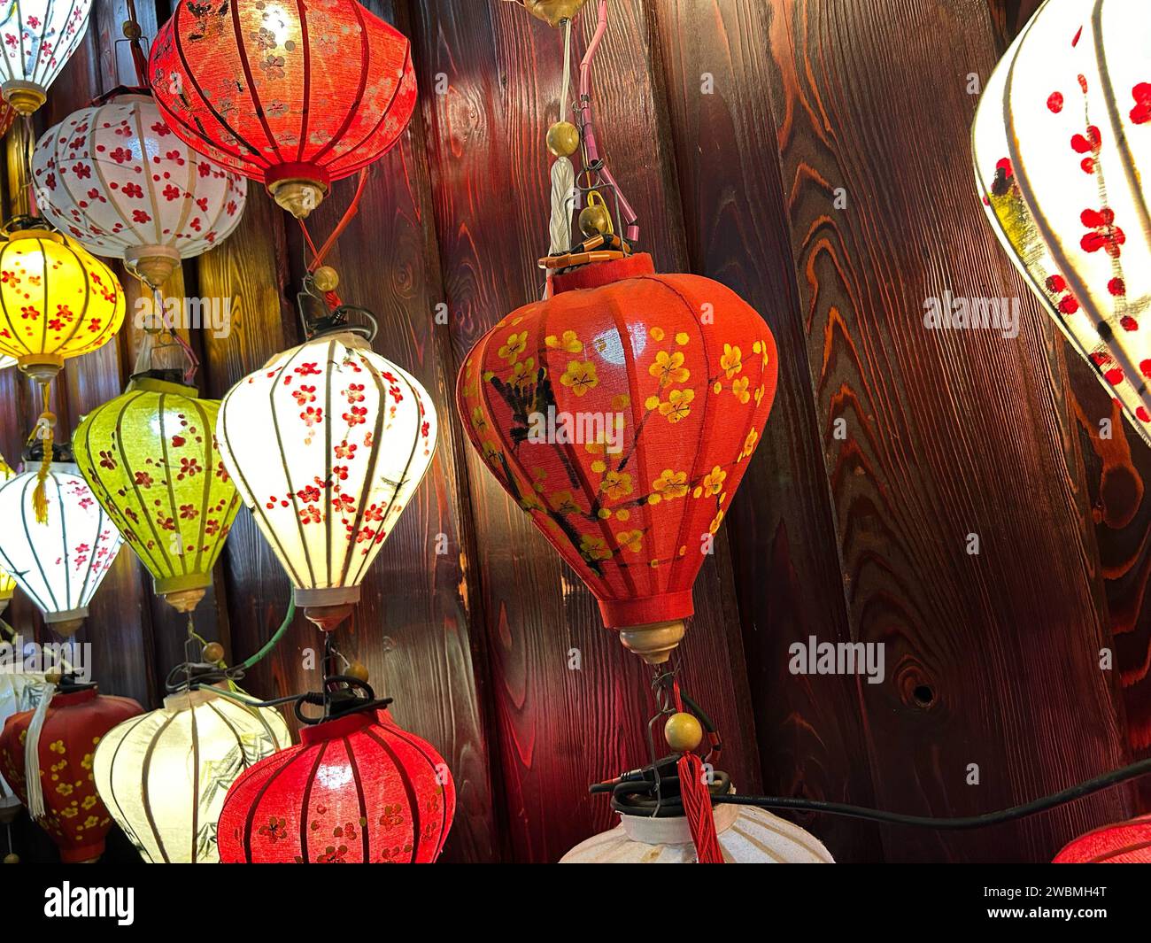 An open door illuminated by a vibrant display of paper lanterns, suspended from the wall Stock ...