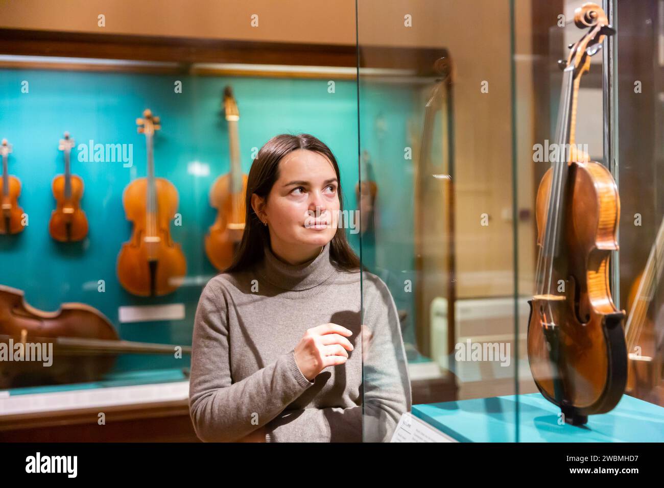 Female museum visitor examining ancient musical instruments Stock Photo ...