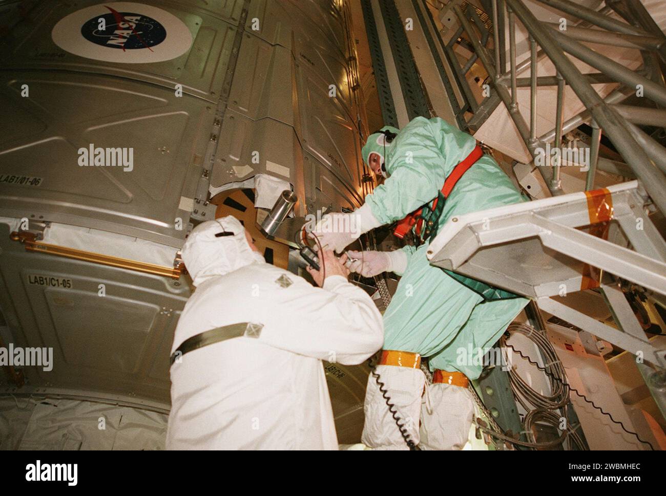 KENNEDY SPACE CENTER, FLA. -- Technicians in the Payload Changeout Room ...