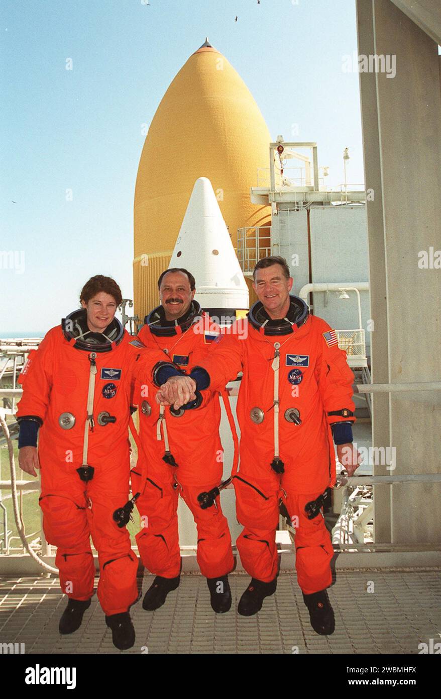 STS-102 Mission Specialists Susan Helms, Yury Usachev and James Voss clasp hands showing their ...
