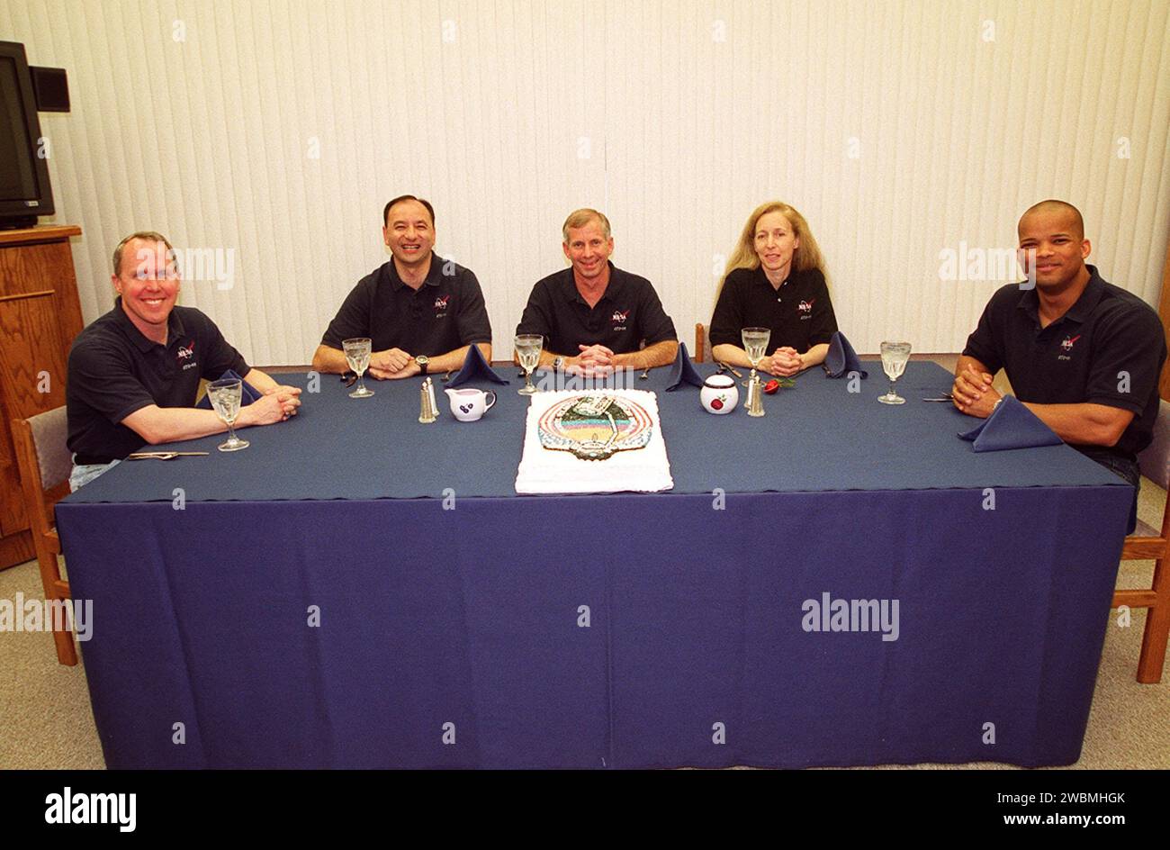 The STS-98 crew gathers around a table for a snack before getting ready ...
