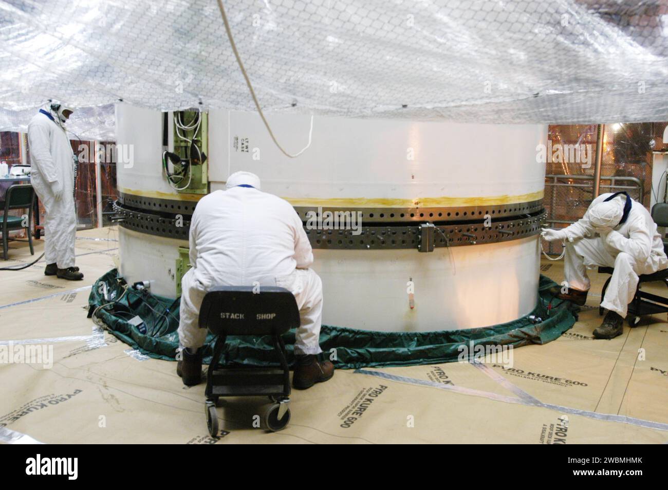 Technicians in the Vehicle Assembly Building align the upper segment ...