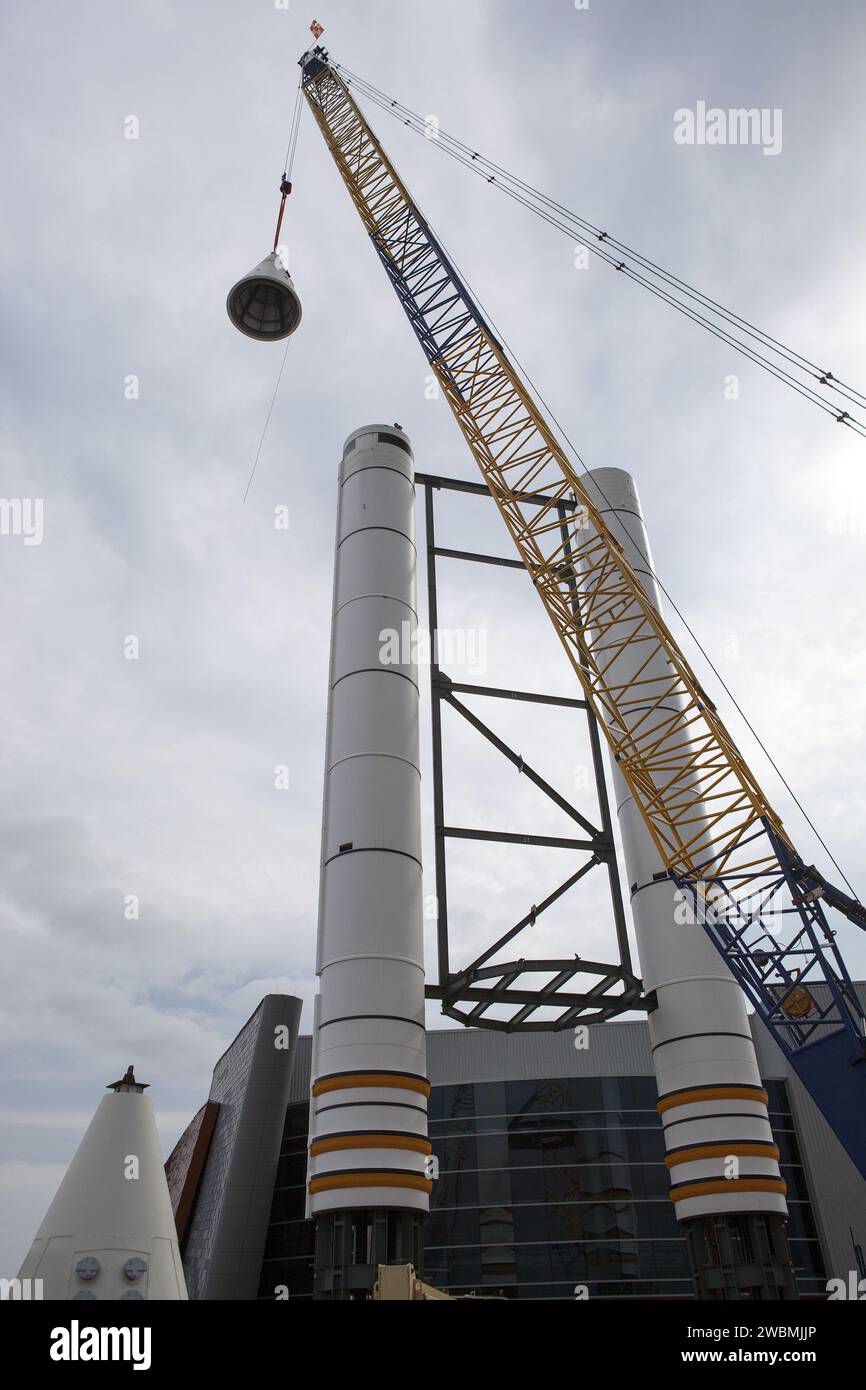 A crane places a nose cone atop a replica solid rocket booster at ...