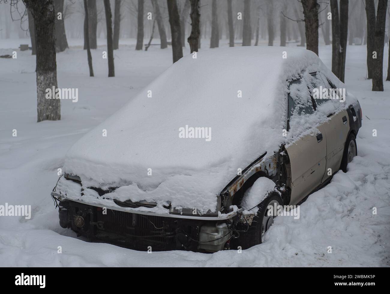 Old smashed car covered in snow. Abandoned car in the snow Stock Photo ...