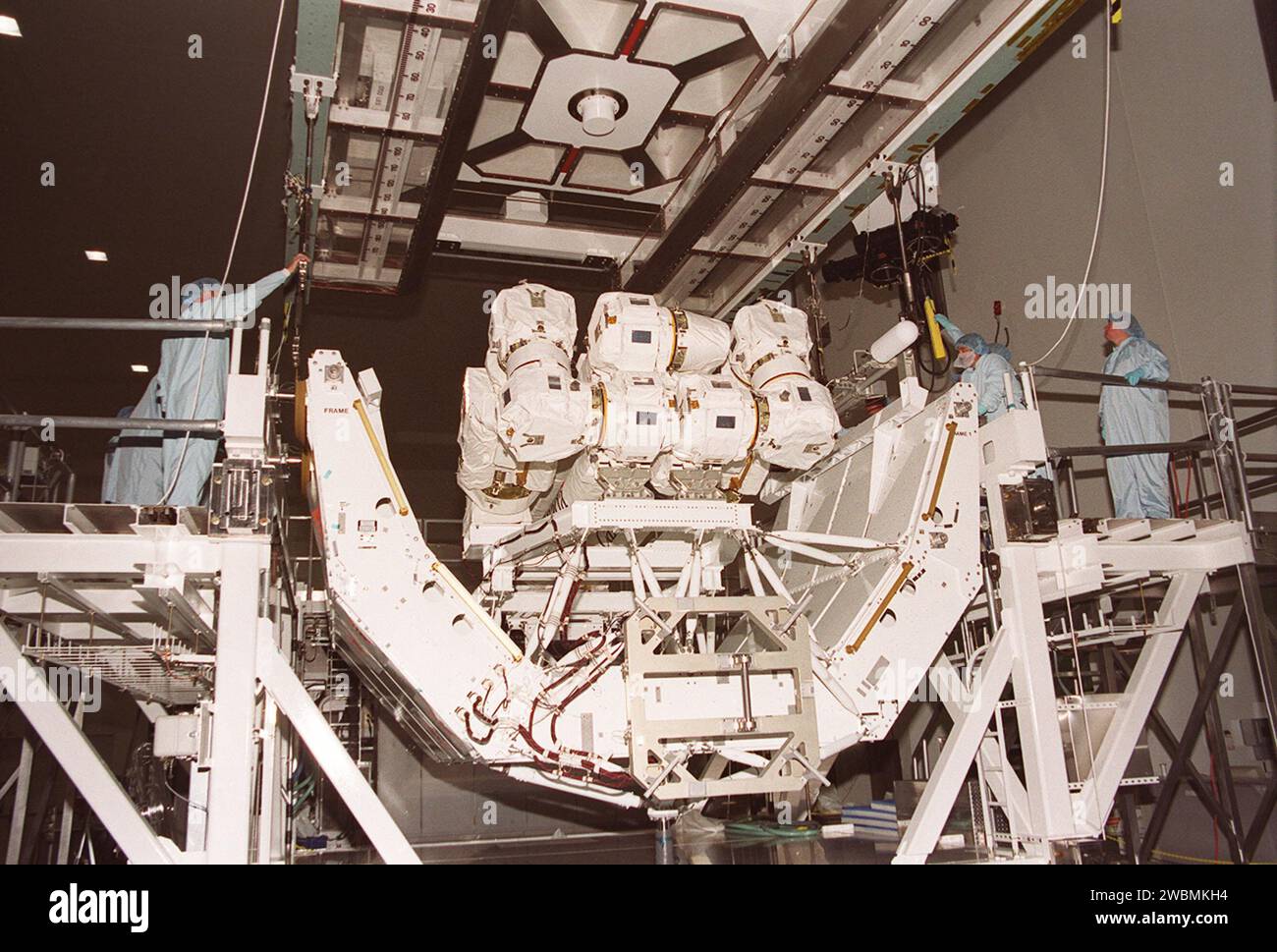 The Canadian robotic arm, SSRMS, is lifted by an overhead crane in the ...