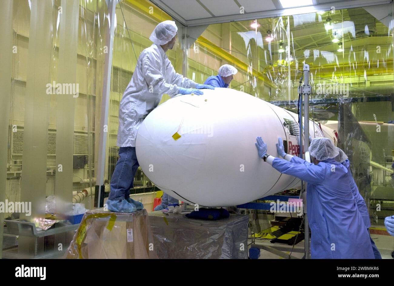 Technicians at Vandenberg AFB install a protective fairing around NASA ...