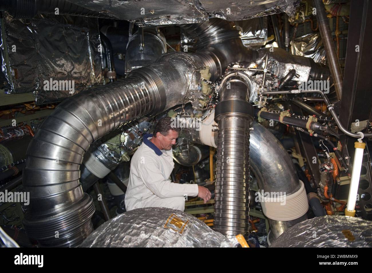 CAPE CANAVERAL, Fla. -- A technician at NASA Kennedy Space Center's Launch Pad 39A crouches in ...