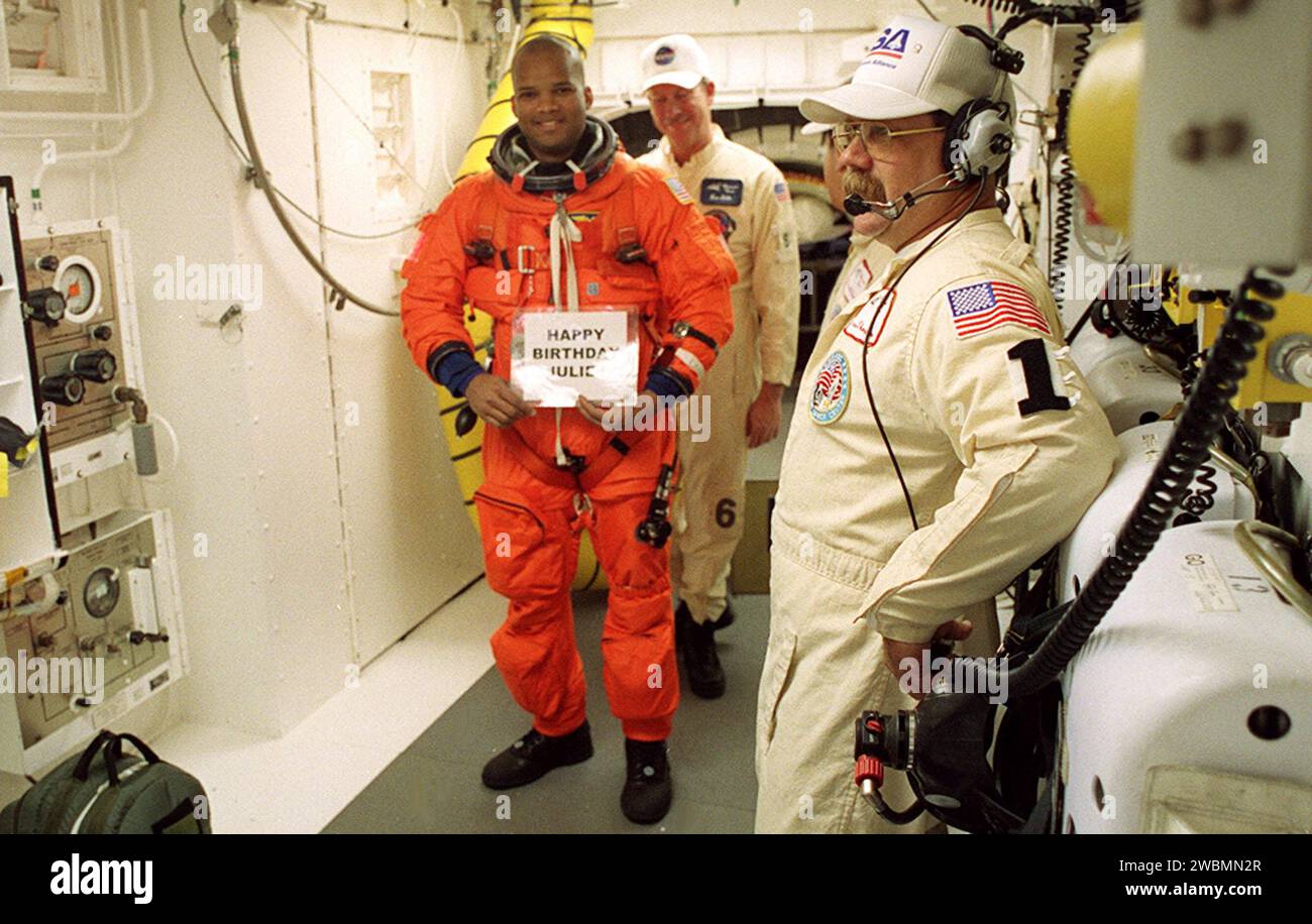 In the White Room with the closeout crew, STS-98 Mission Specialist Robert Curbeam sends a ...